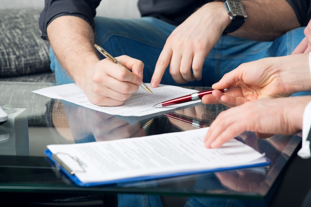 Two people signing a document - Texas Divorce Lawyers
